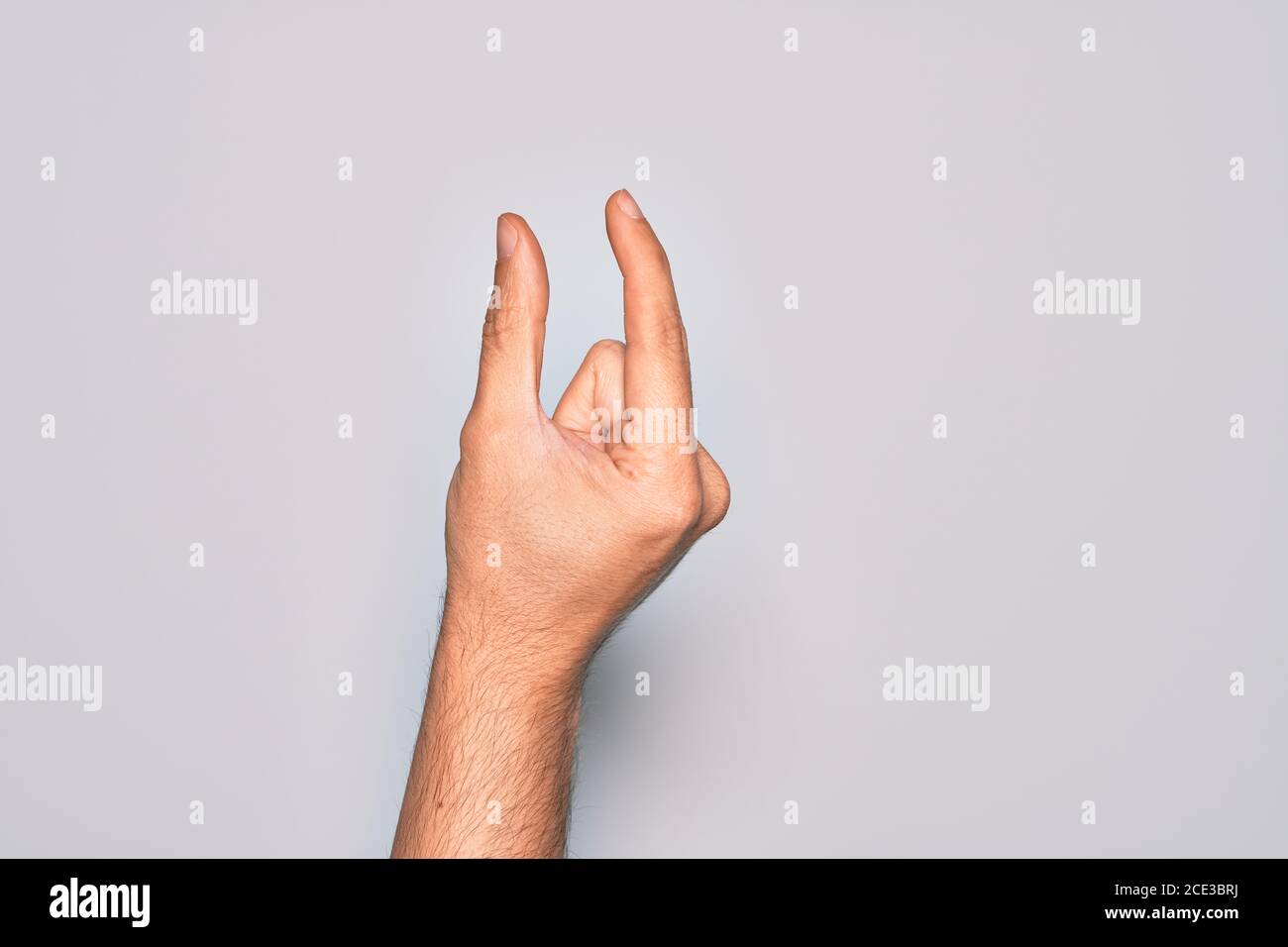 Hand of caucasian young man showing fingers over isolated white background picking and taking ...
