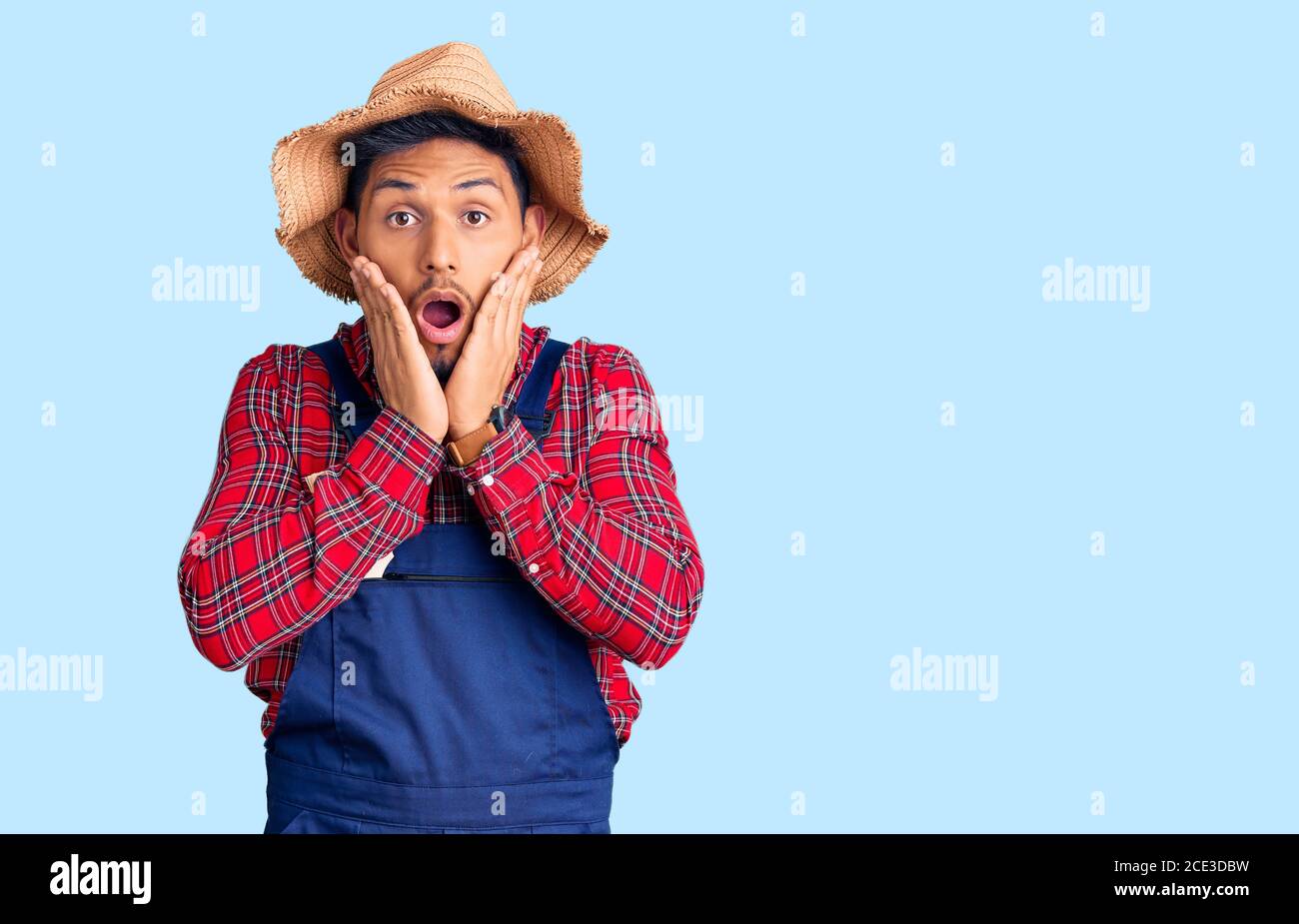 Handsome latin american young man weaing handyman uniform afraid and ...