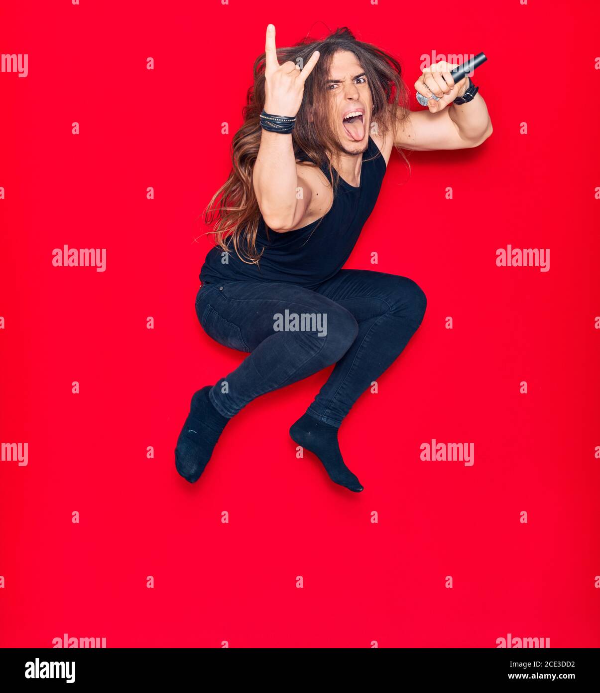 Young handsome heavy metal singer man with long hair and aggressive ...