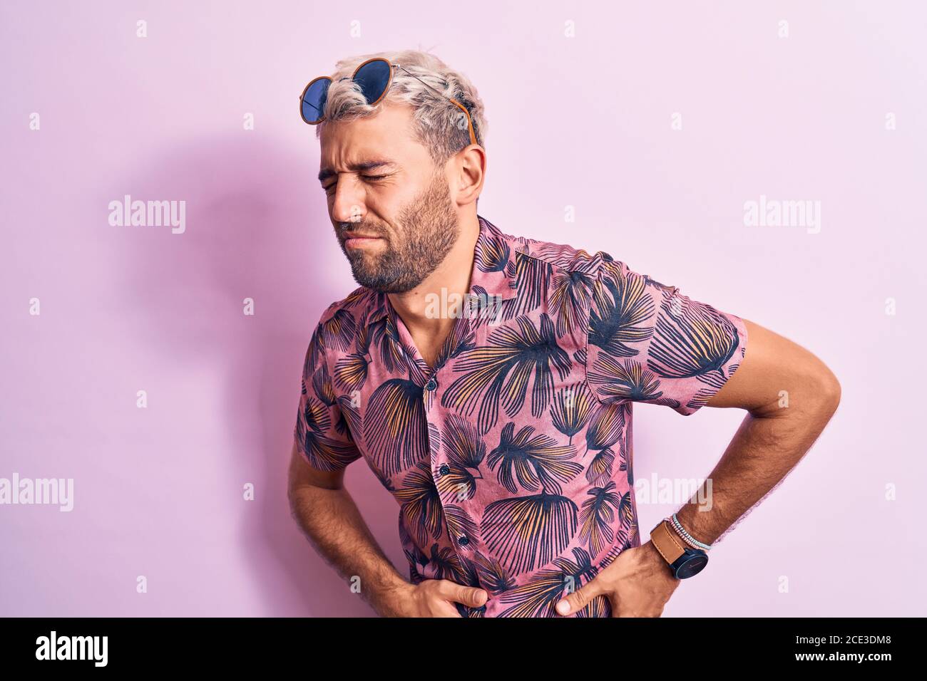 Handsome blond man on vacation wearing casual shirt and sunglasses over ...