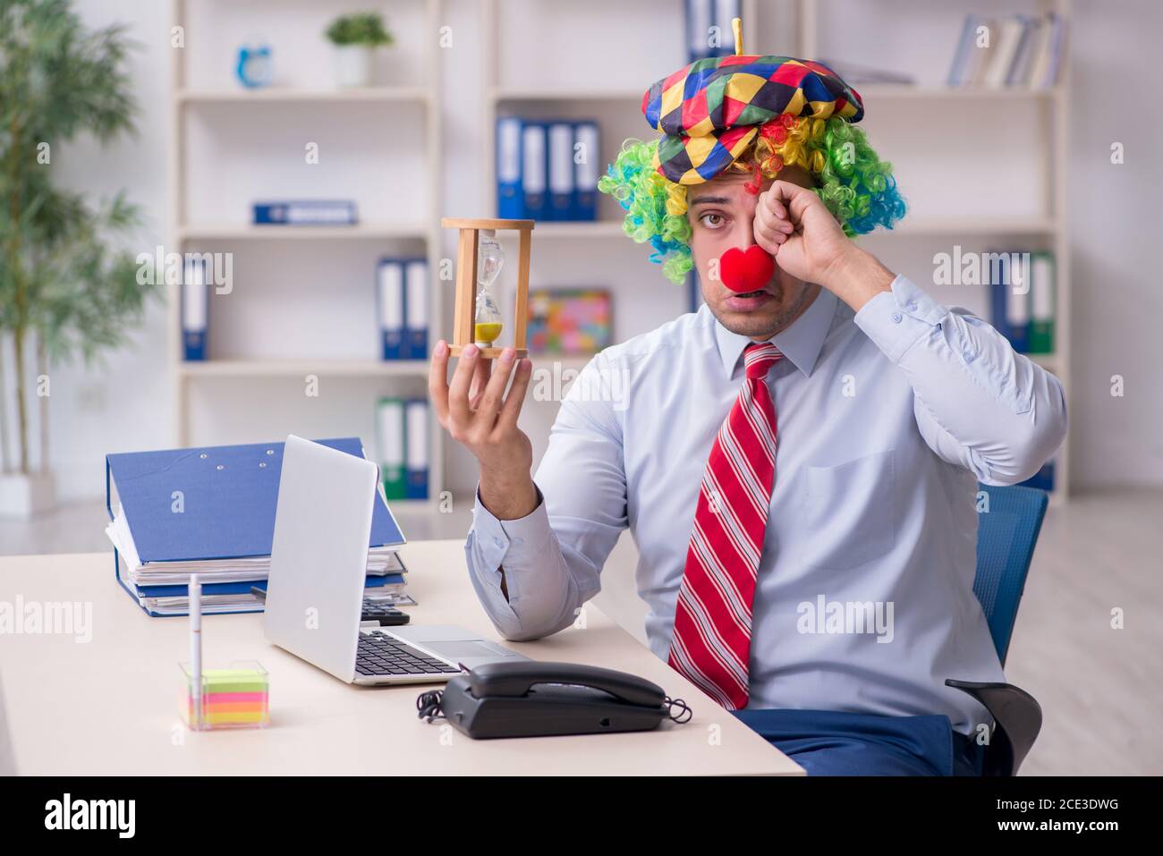 Funny employee clown working in the office room Stock Photo - Alamy