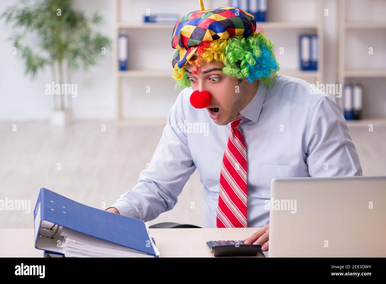 Funny employee clown working in the office room Stock Photo - Alamy