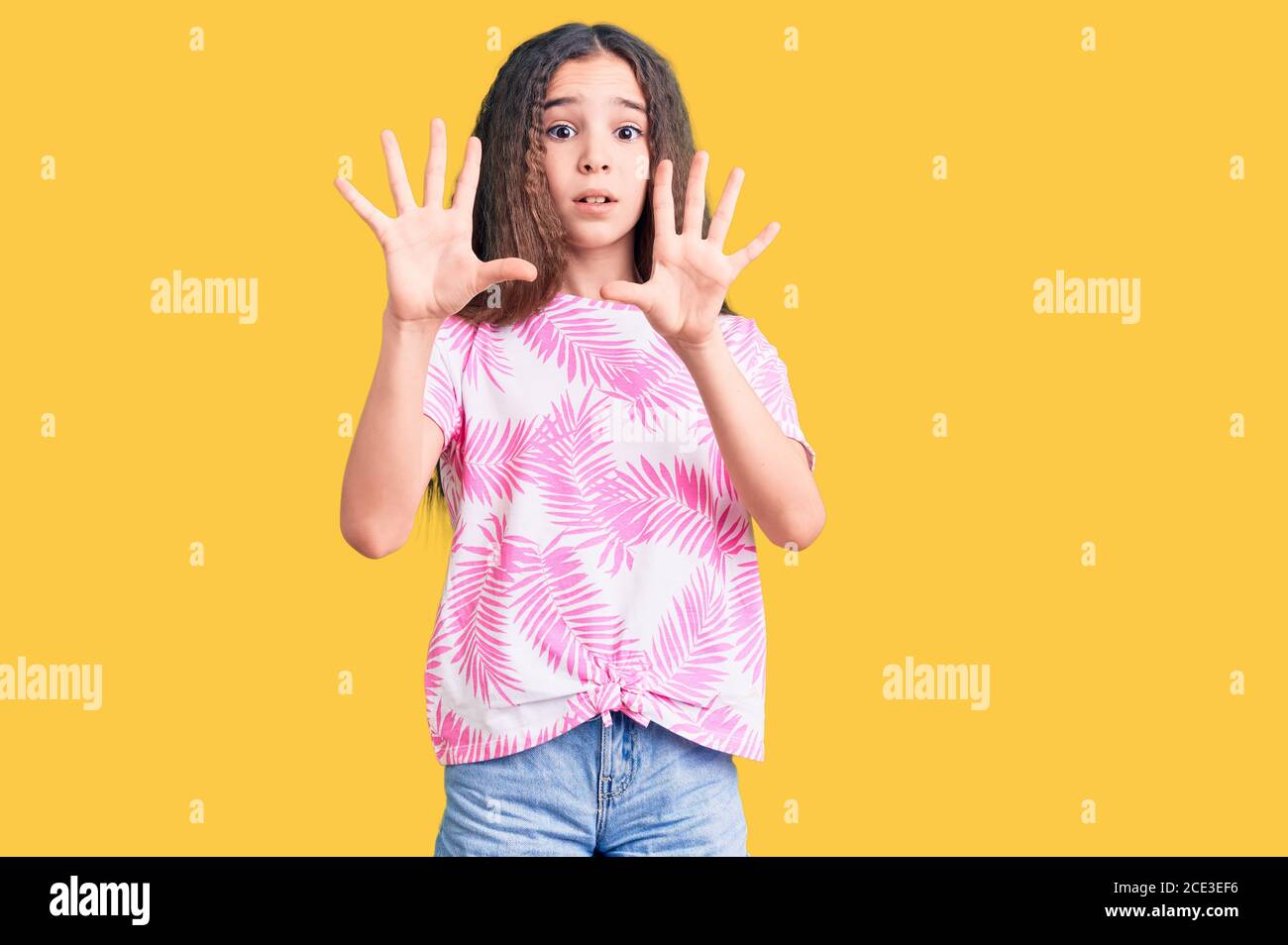Cute hispanic child girl wearing casual clothes afraid and terrified ...