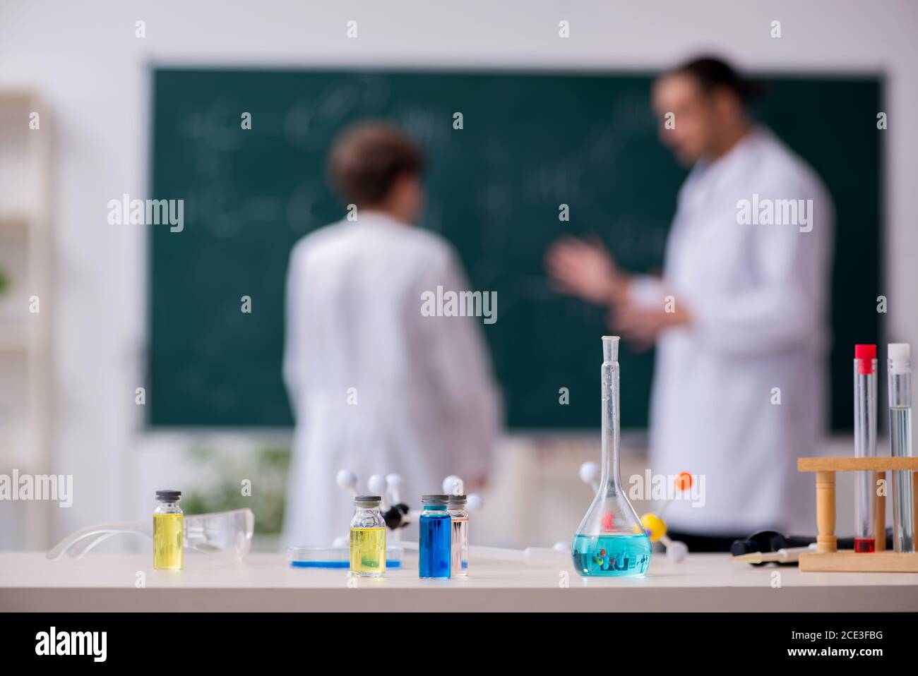 Young chemistry teacher and schoolboy in classroom Stock Photo - Alamy