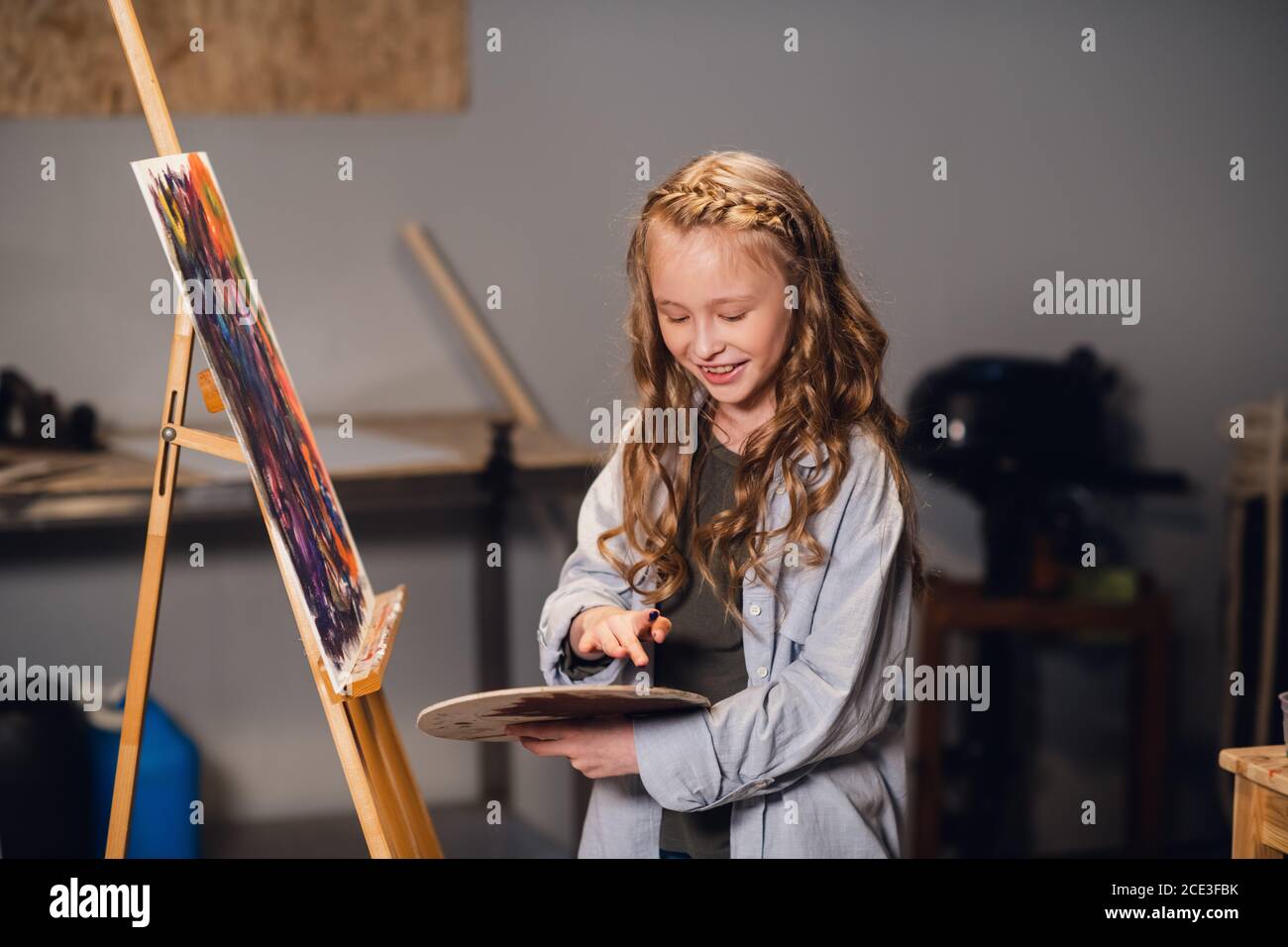 An art school student mixes colors on a palette for her canvas drawing ...