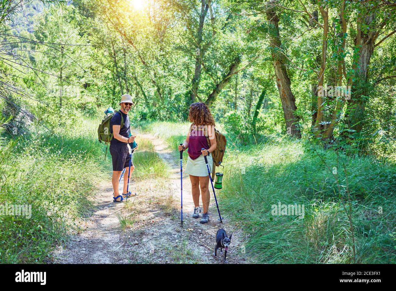 Beautiful couple of hiker wearing backpack smiling happy. Standing with ...