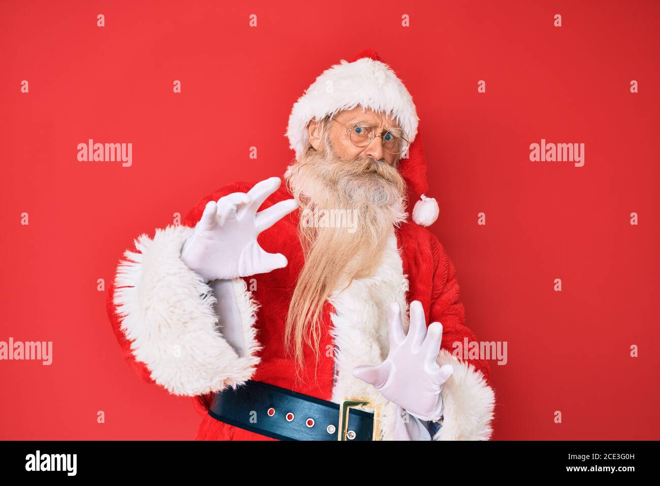 Old senior man with grey hair and long beard wearing traditional santa ...