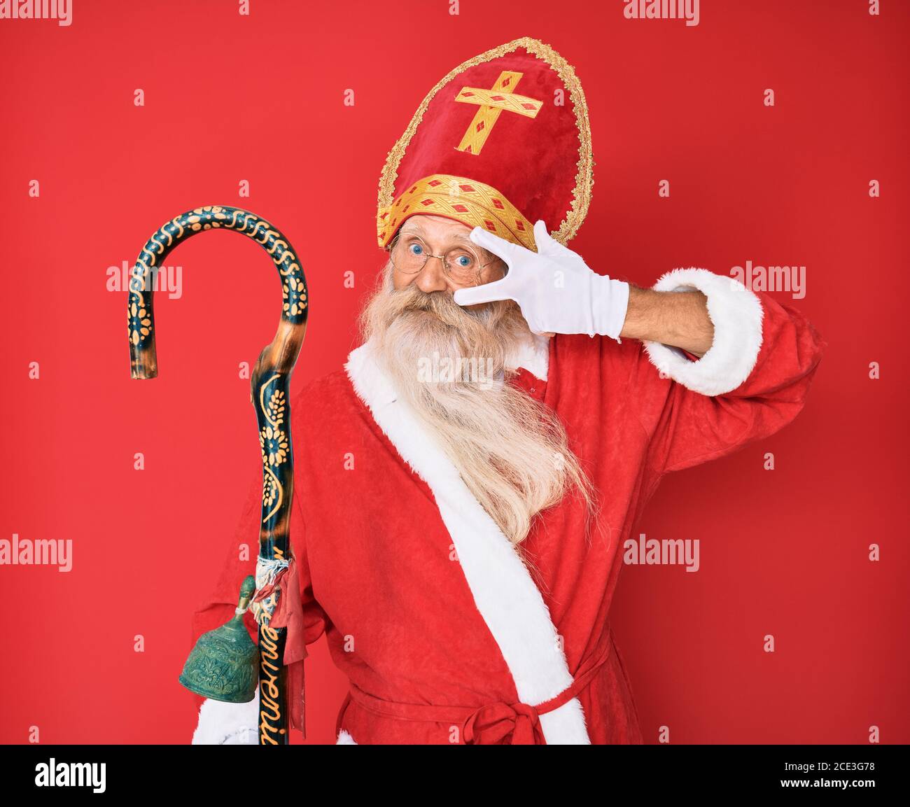 Old senior man with grey hair and long beard wearing traditional saint ...