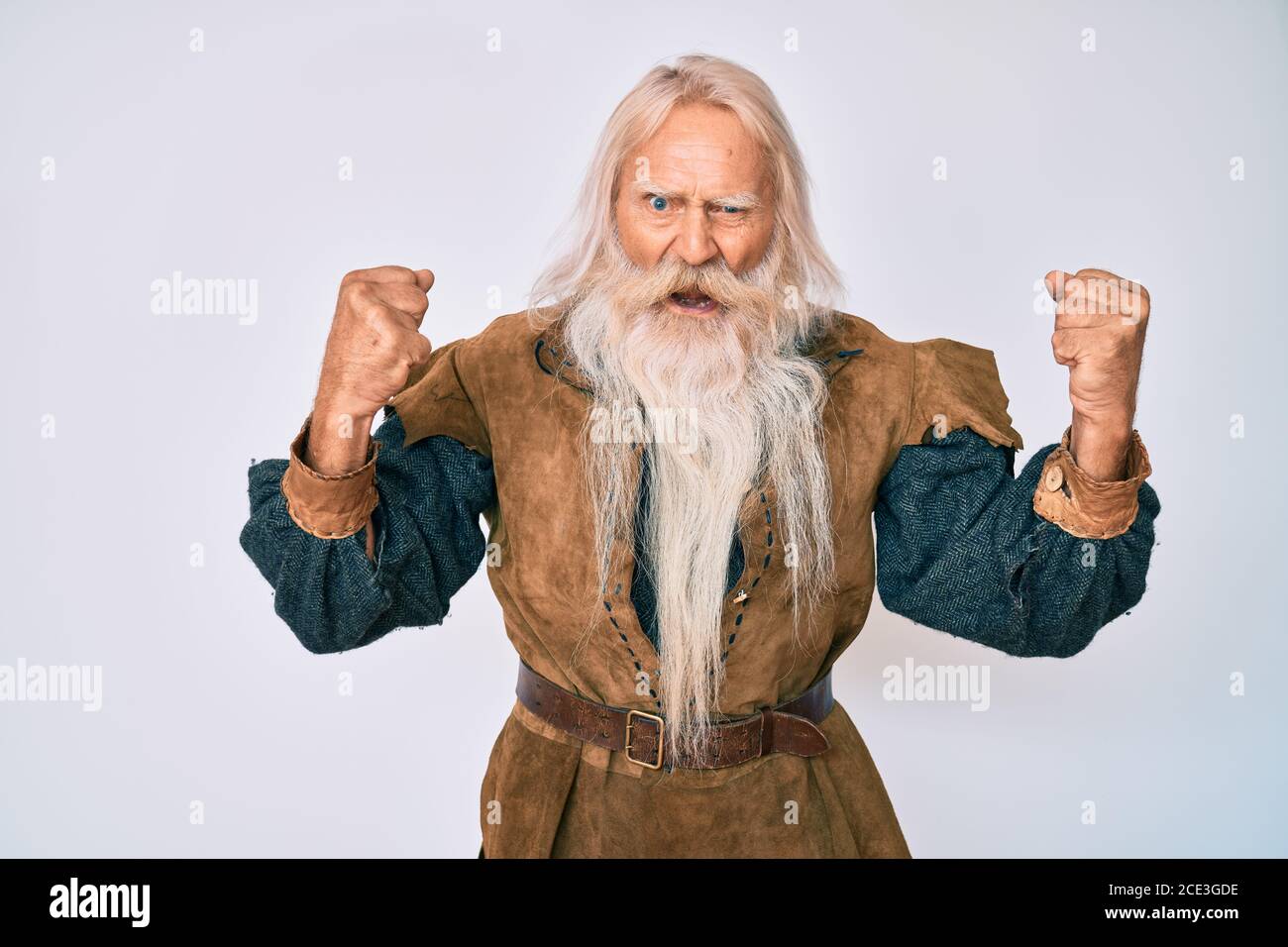 Old senior man with grey hair and long beard wearing viking traditional ...