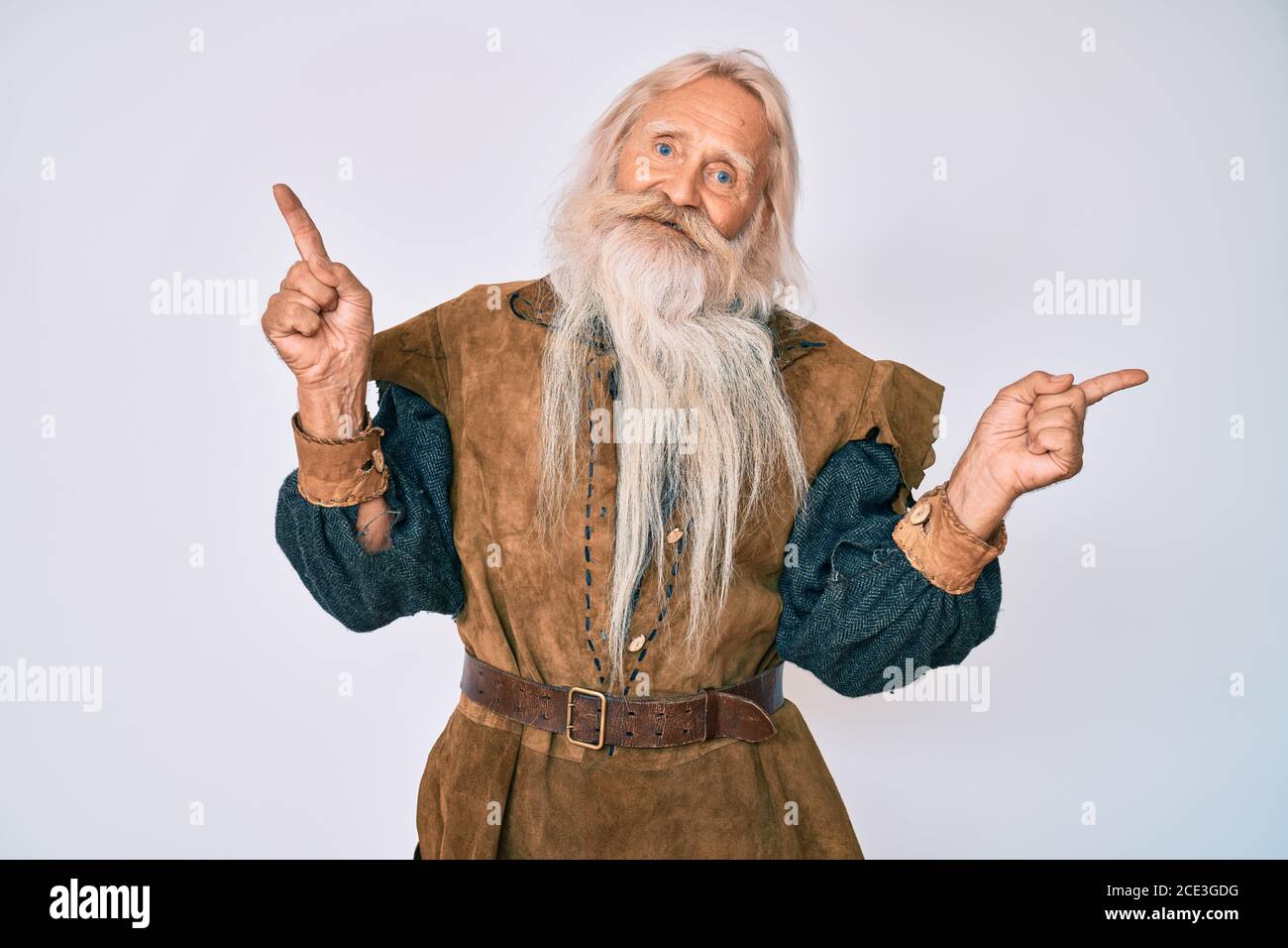 Old senior man with grey hair and long beard wearing viking traditional ...