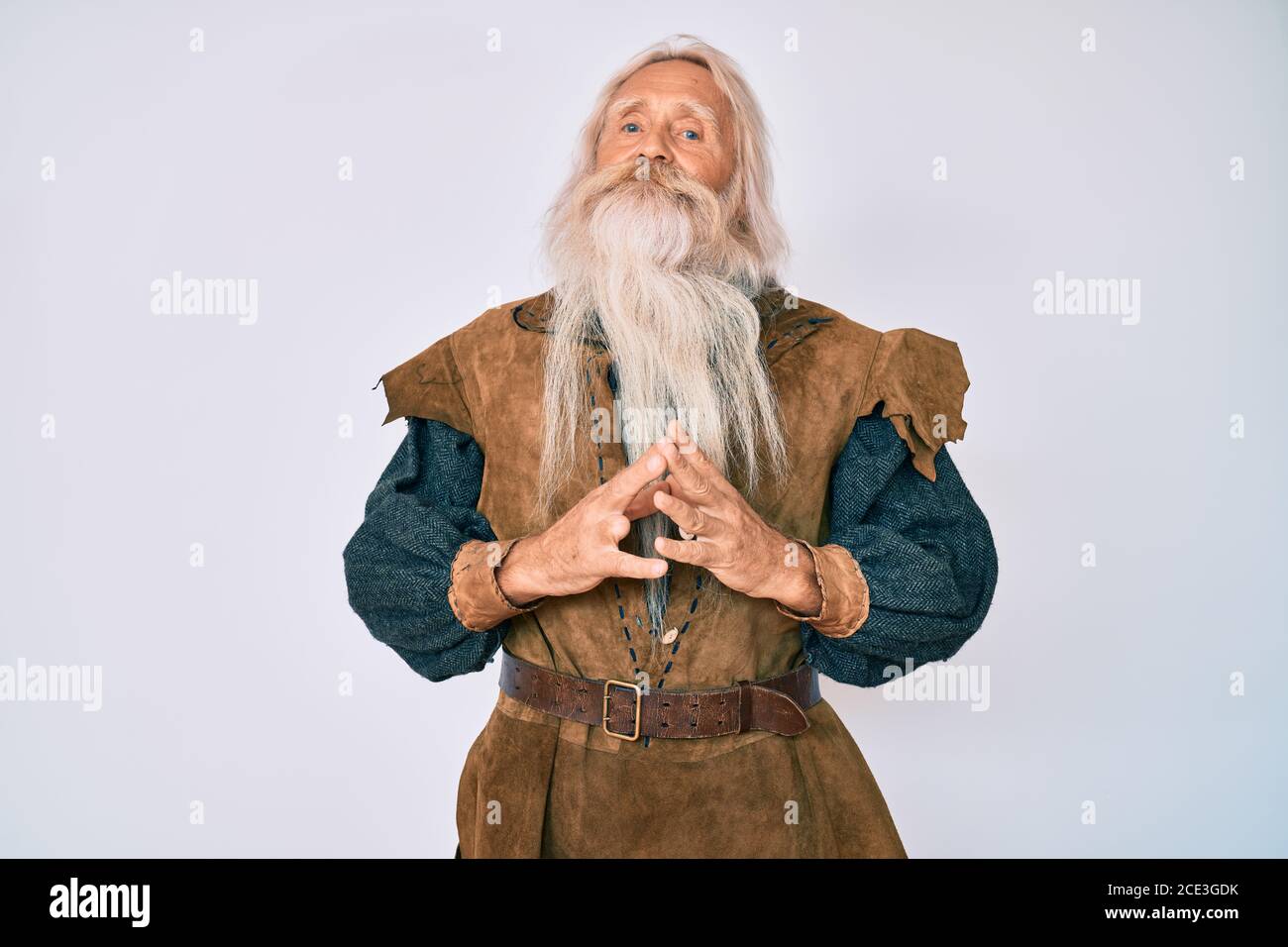 Old senior man with grey hair and long beard wearing viking traditional ...