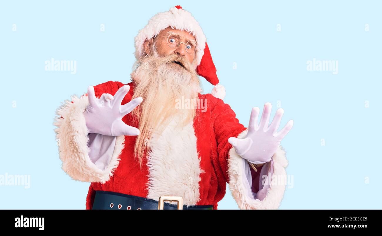 Old senior man with grey hair and long beard wearing traditional santa ...