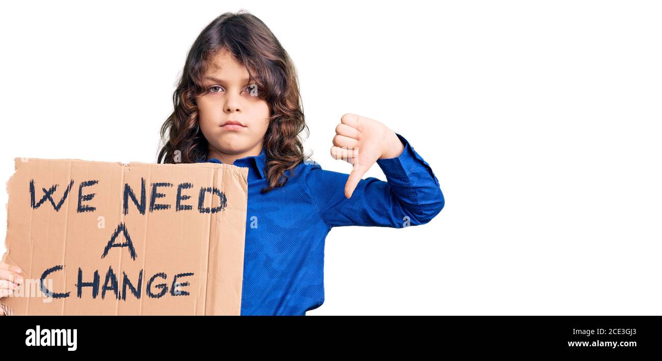 Cute hispanic child with long hair holding we need a change banner with ...