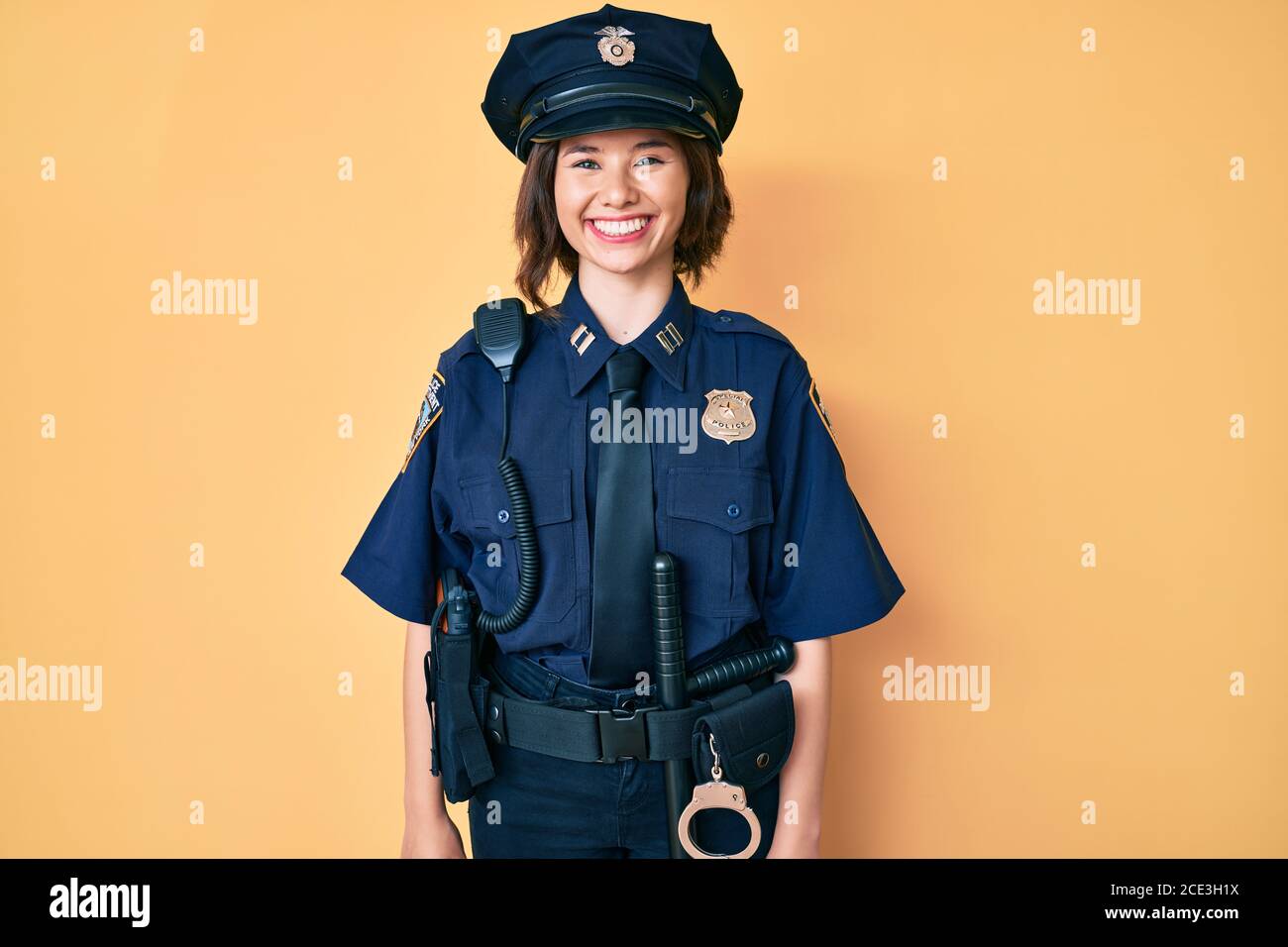 Young beautiful woman wearing police uniform happy face smiling with ...