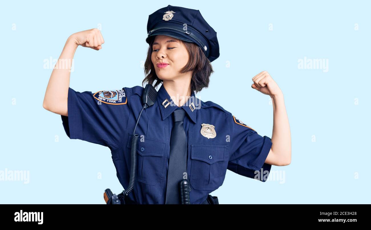 Young beautiful girl wearing police uniform showing arms muscles ...