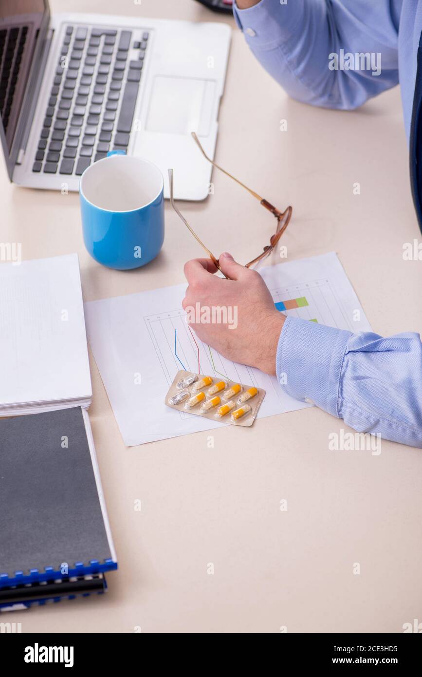 Sick male employee suffering at the workplace Stock Photo - Alamy