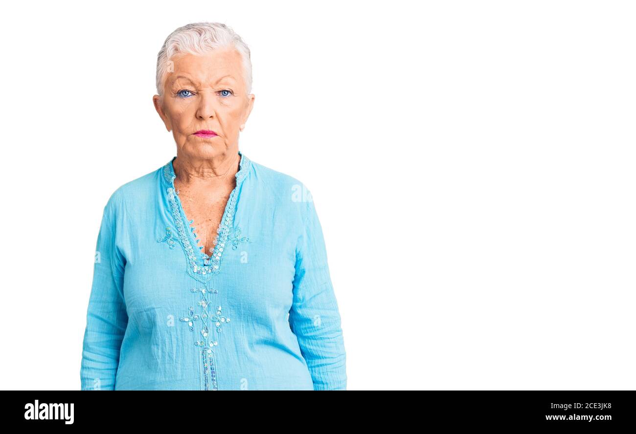 Senior beautiful woman with blue eyes and grey hair wearing summer ...