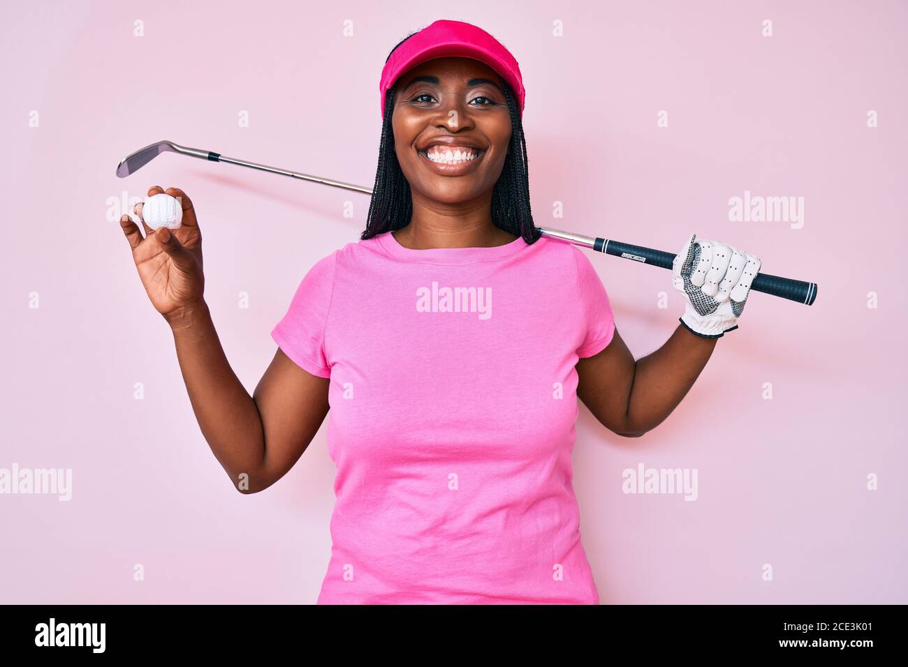 African american golfer woman with braids holding golf ball smiling ...