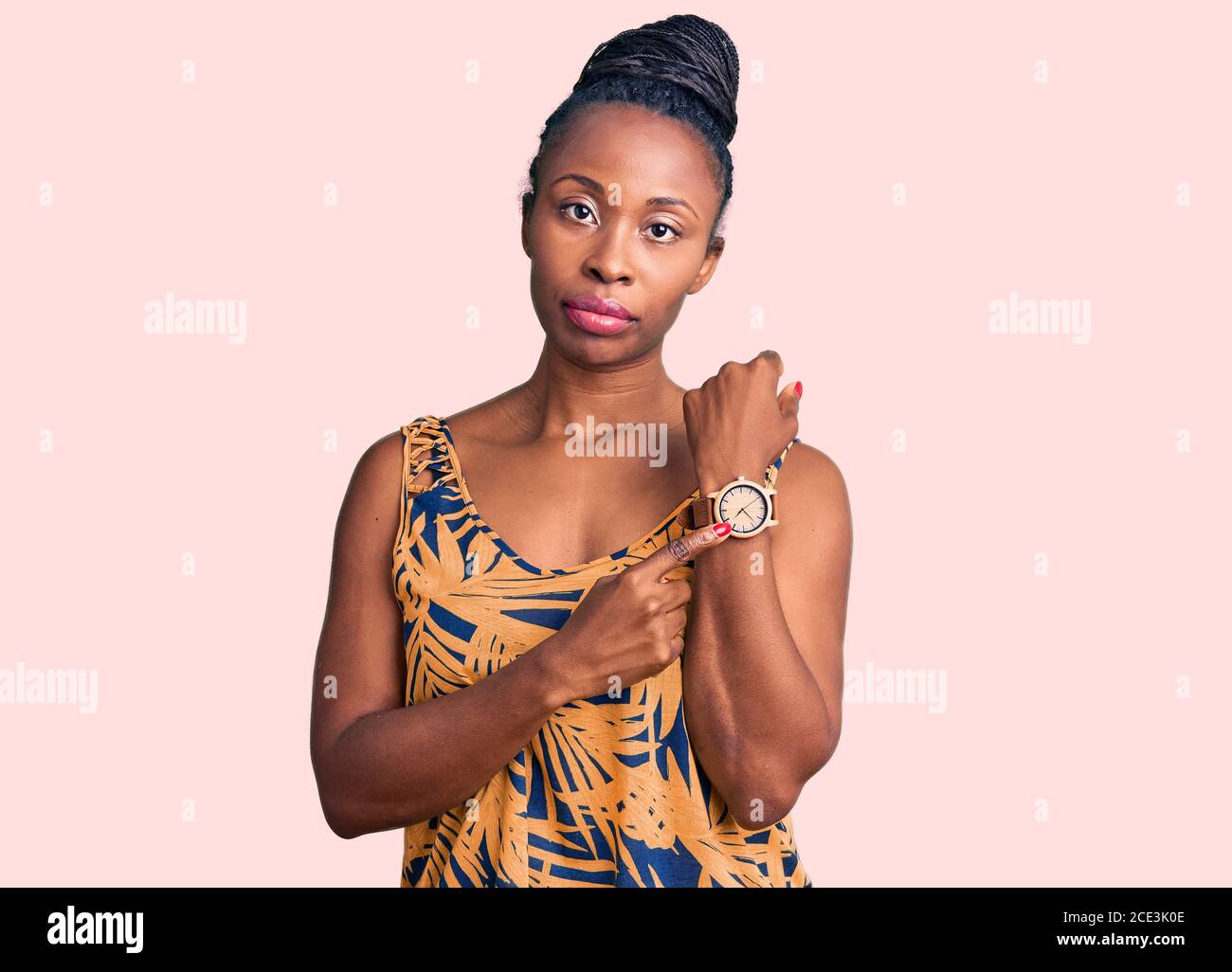 Young african american woman wearing casual clothes in hurry pointing ...