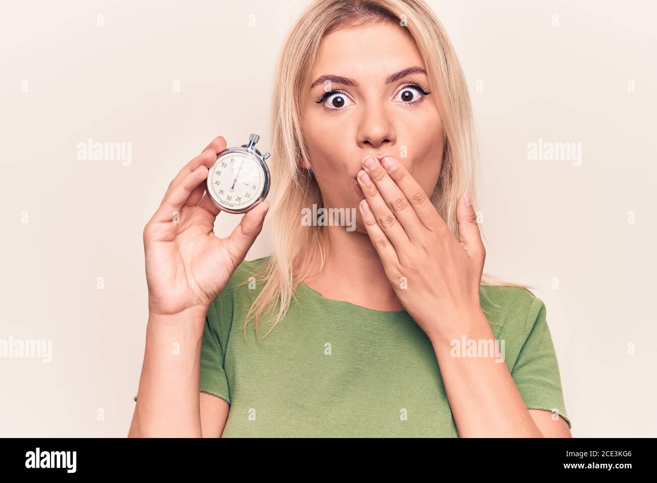 Young beautiful blonde woman doing countdown using stopwatch over white ...