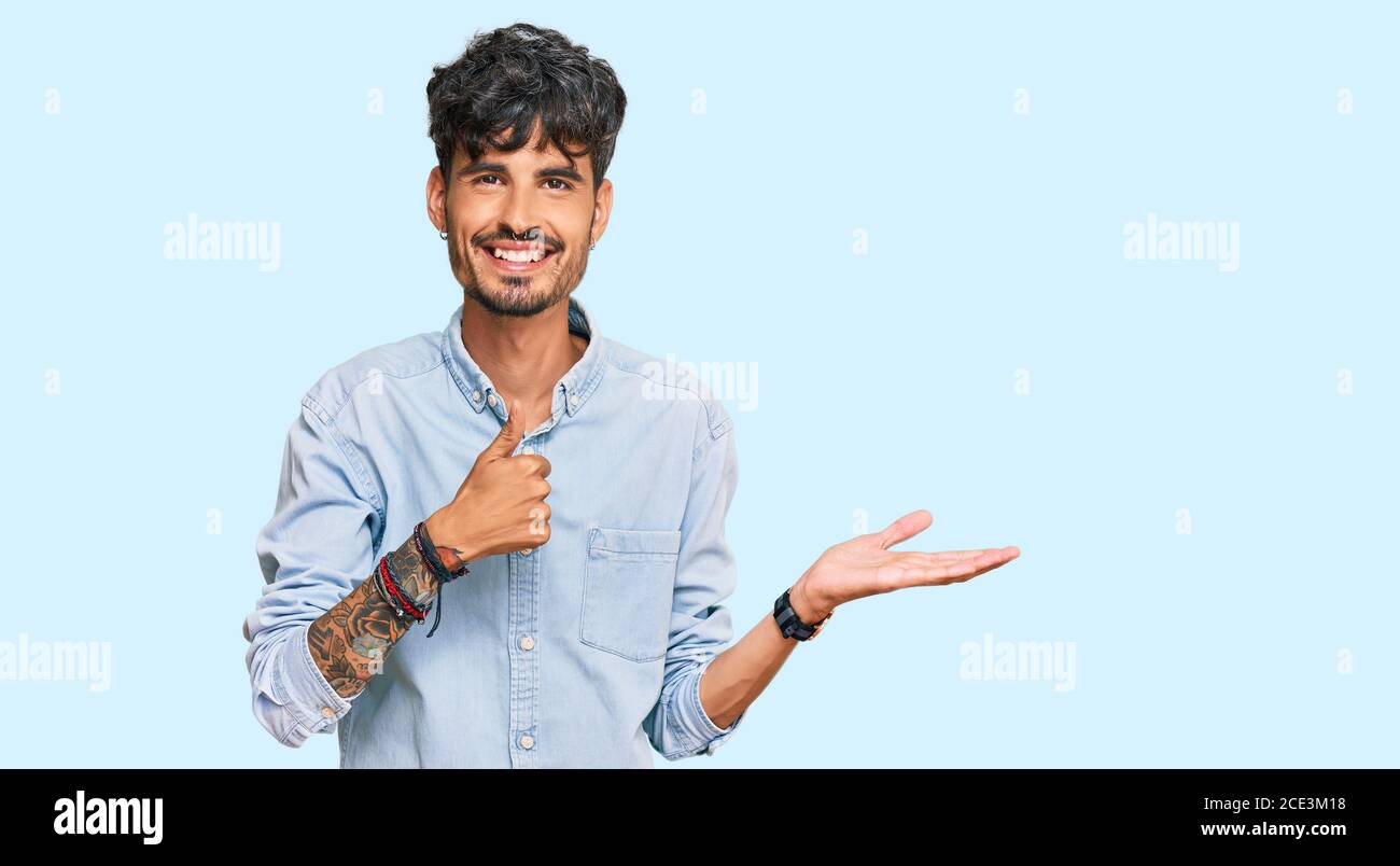 Young hispanic man wearing casual clothes showing palm hand and doing ...