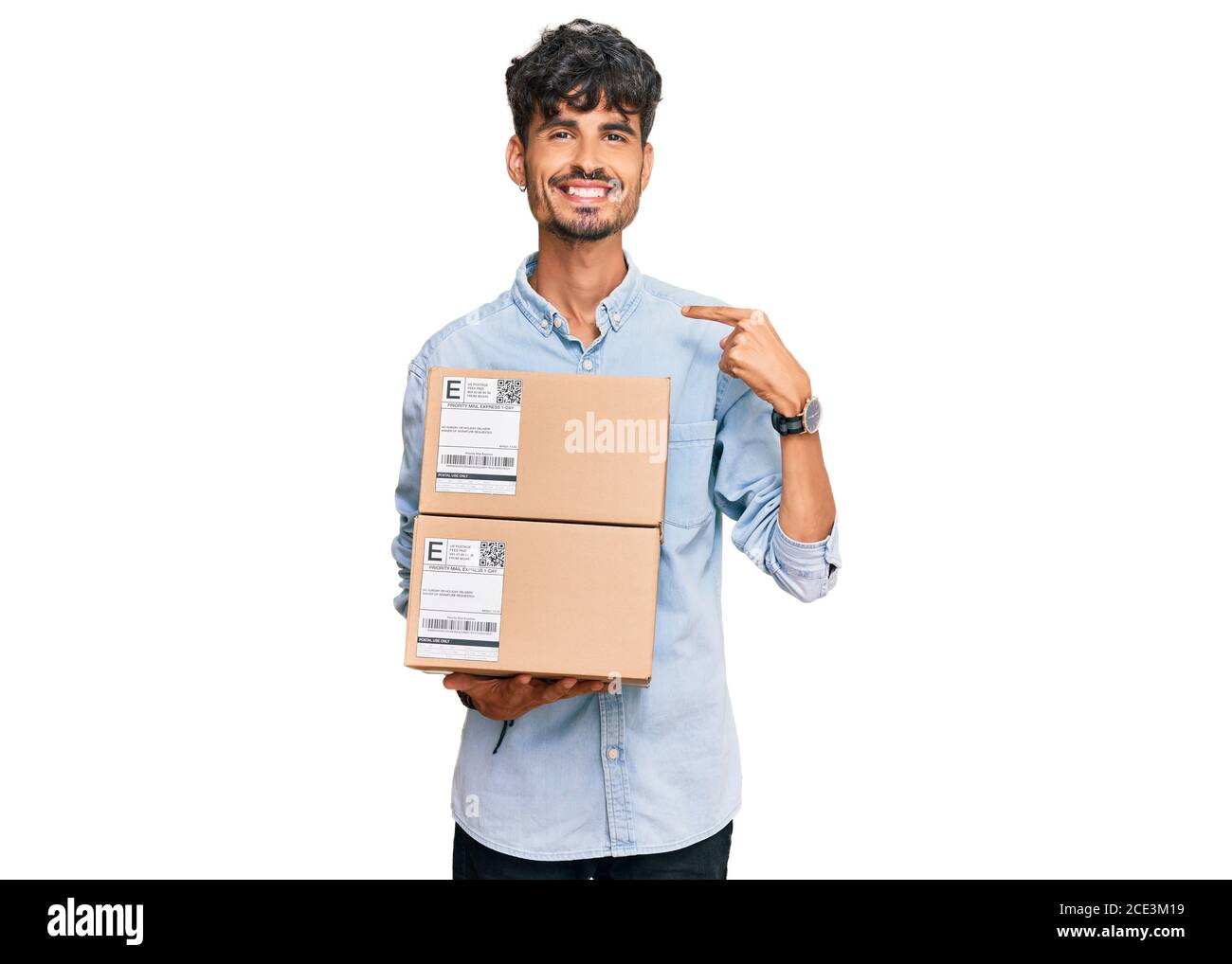 Young hispanic man holding delivery package pointing finger to one self ...