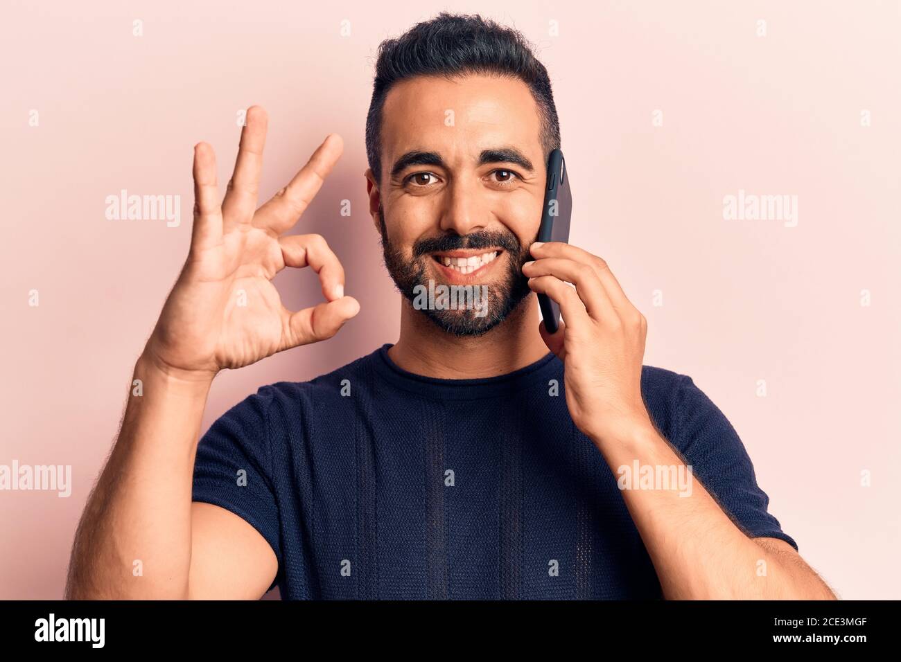 Young hispanic man having conversation talking on the smartphone doing ...