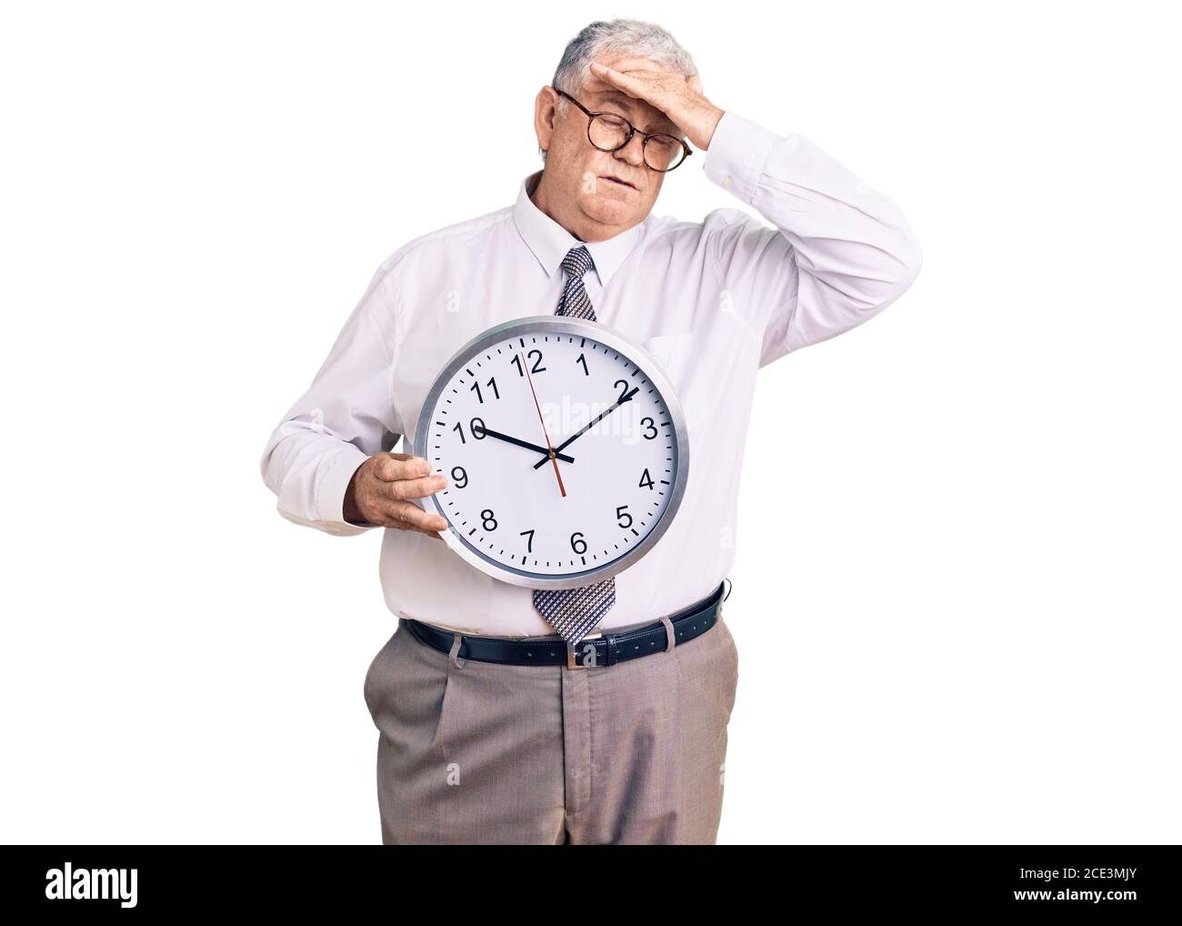 Senior grey-haired man wearing business clothes and holding clock ...