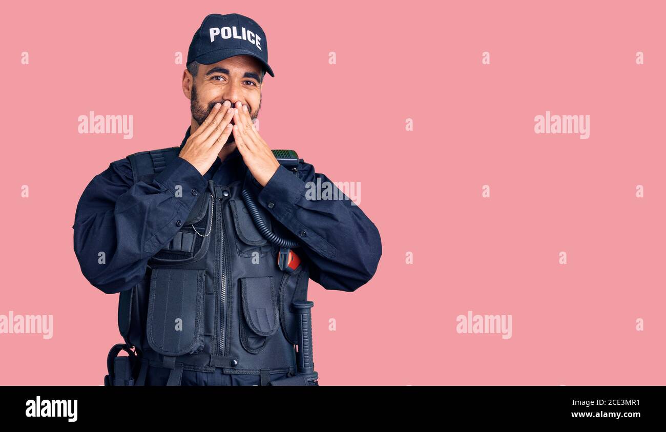 Young hispanic man wearing police uniform laughing and embarrassed ...