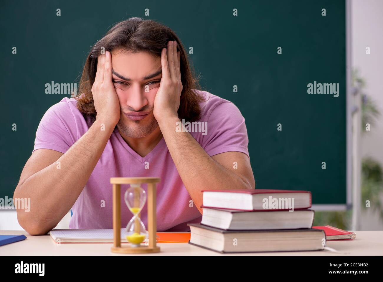 Young student in the classroom at time management concept Stock Photo ...