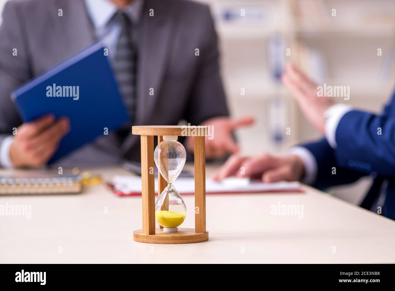 Two businessmen in the time management concept Stock Photo - Alamy