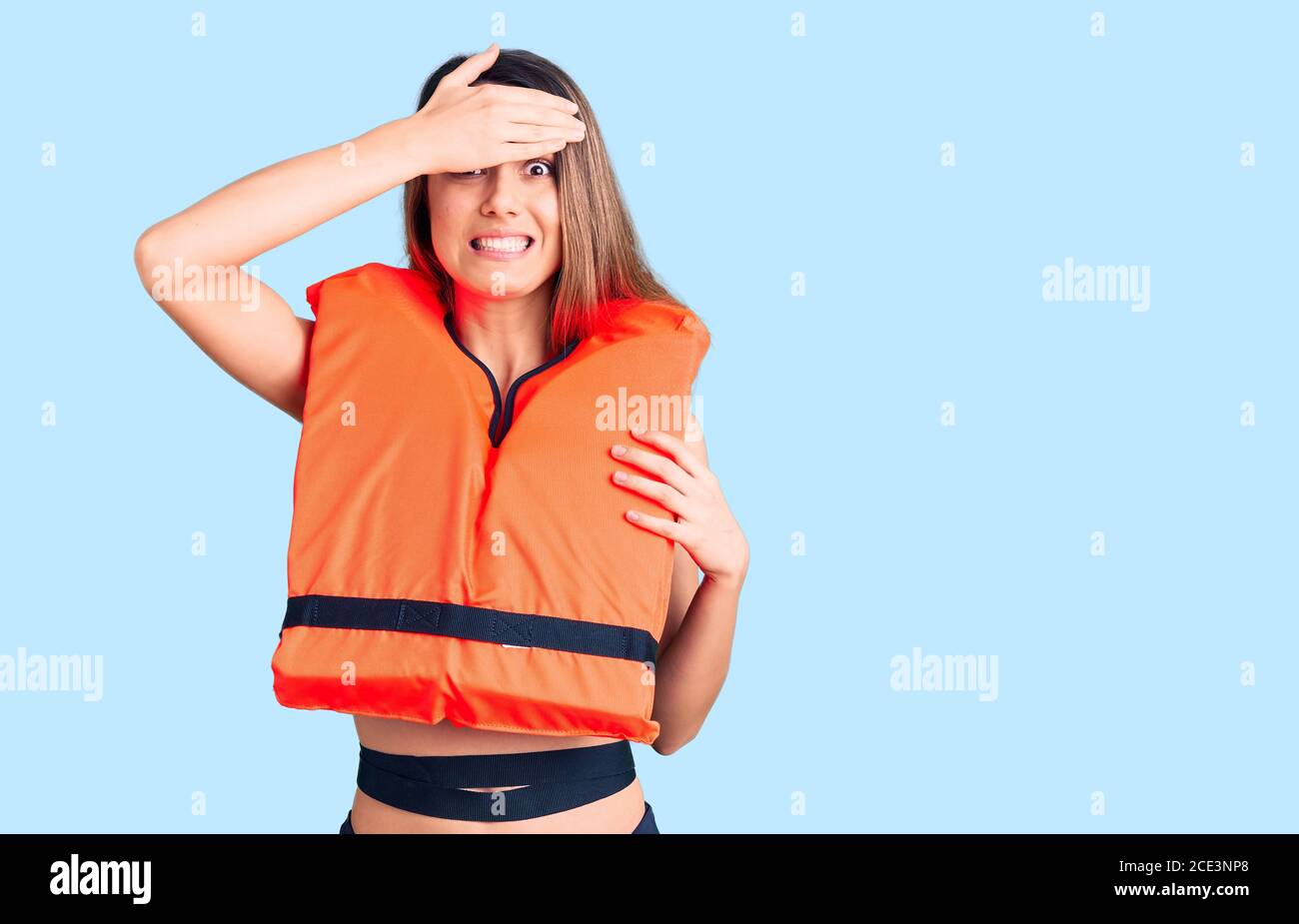 Young beautiful girl wearing life jacket stressed and frustrated with ...