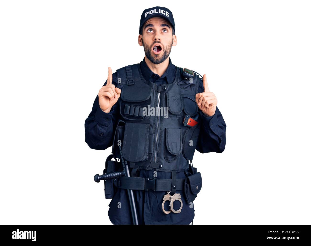 Young handsome man with beard wearing police uniform amazed and ...