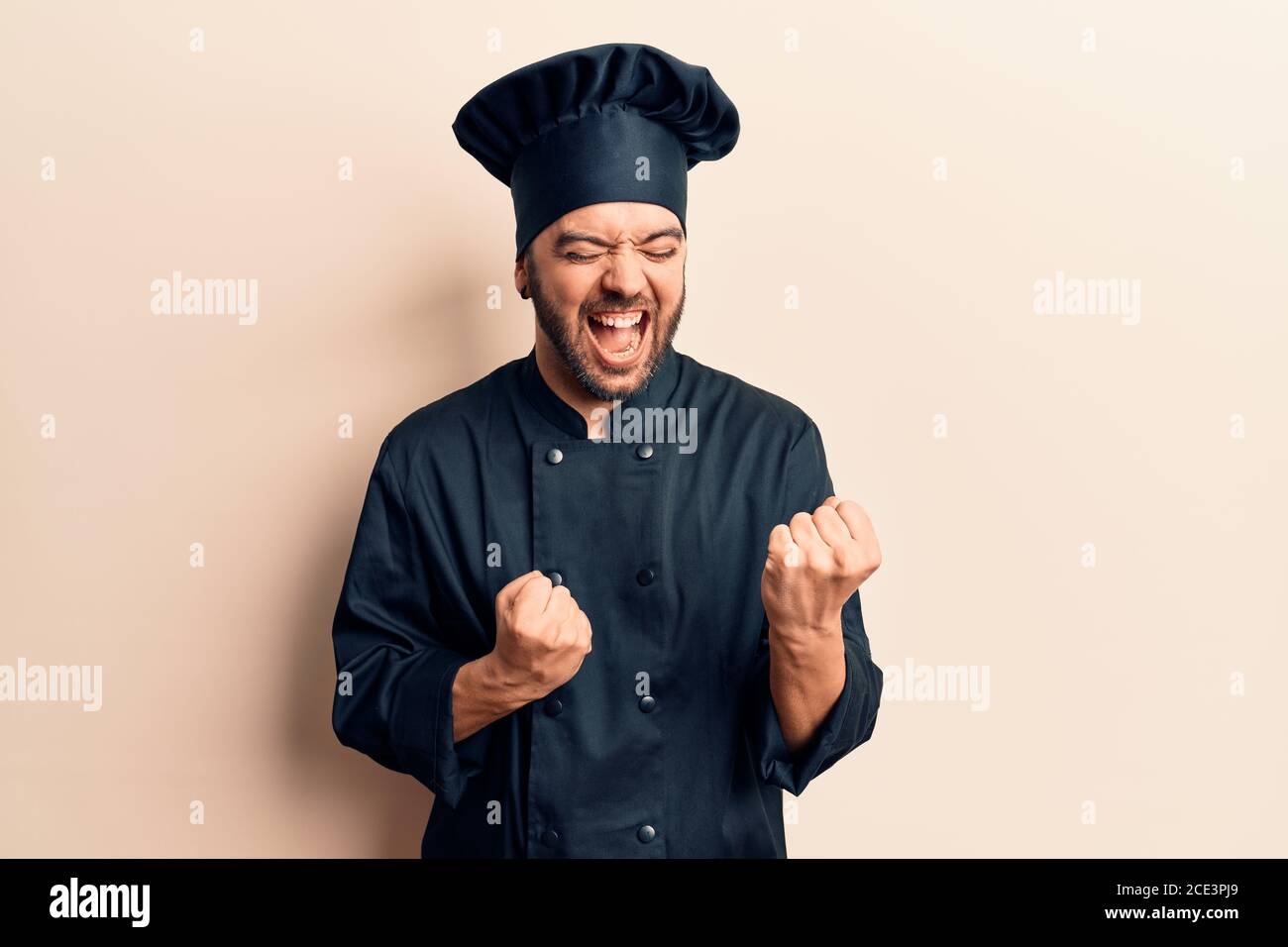 Young hispanic man wearing cooker uniform celebrating surprised and ...