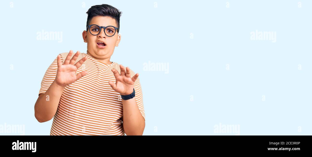 Little boy kid wearing casual clothes and glasses afraid and terrified ...