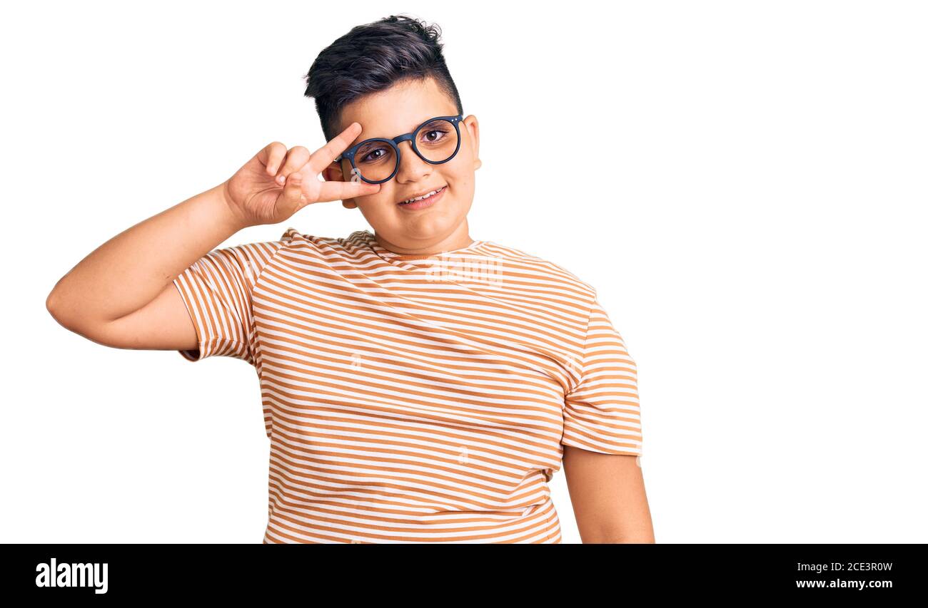 Little boy kid wearing casual clothes and glasses doing peace symbol ...