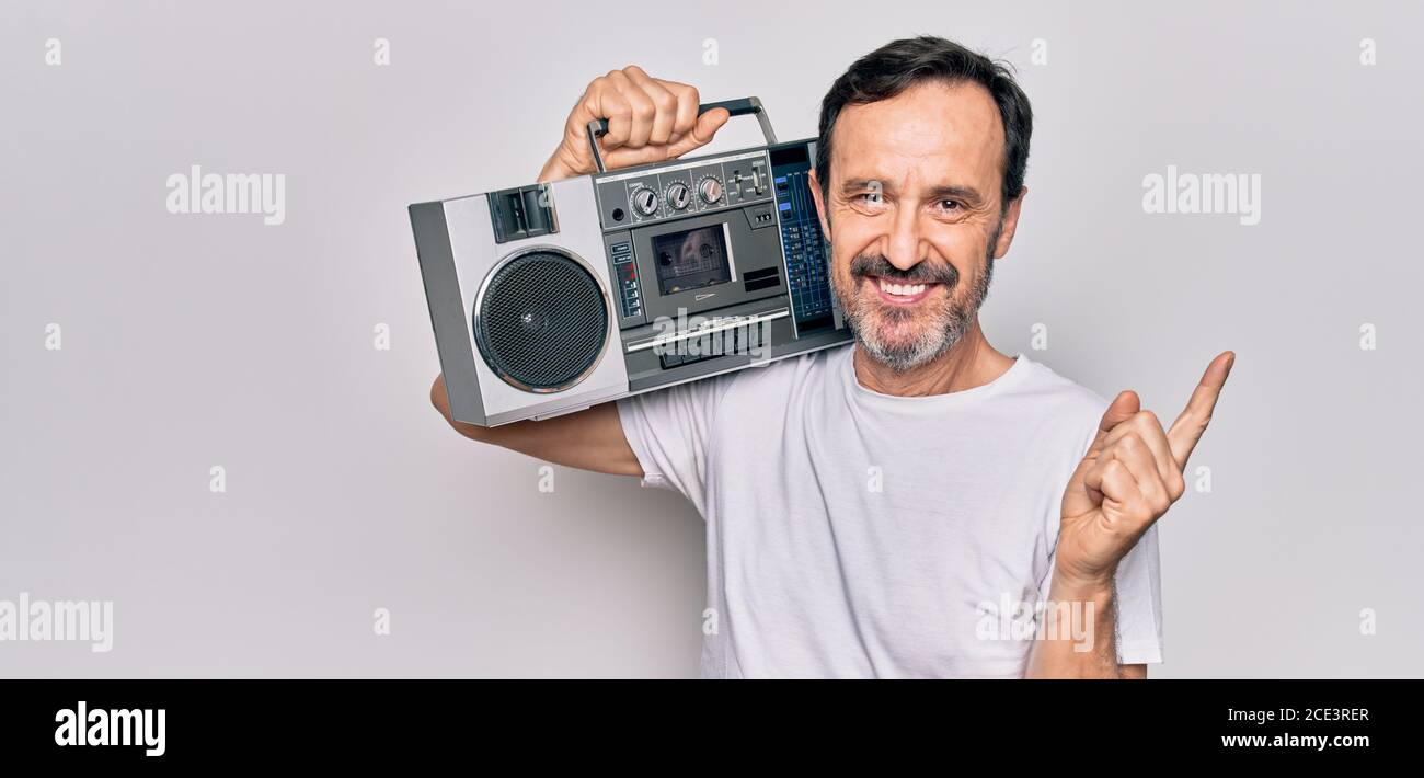 Middle age handsome man listening vintage boombox over isolated white ...