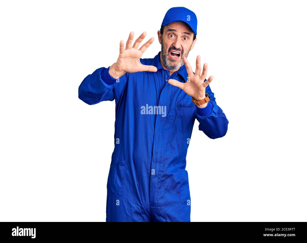 Middle age handsome man wearing mechanic uniform afraid and terrified ...