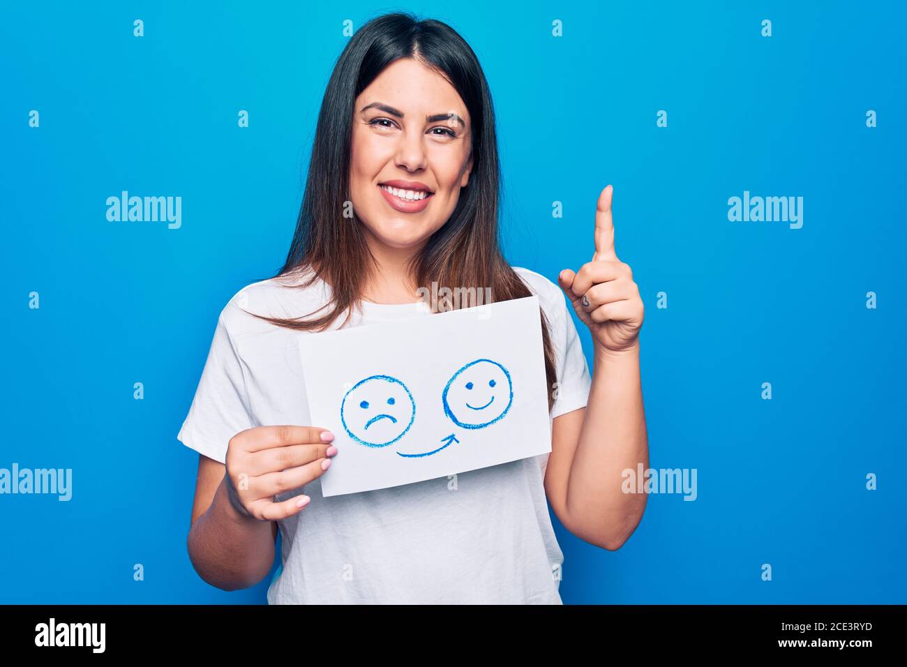 Woman asking for psychology change holding paper with unhappy to happy ...