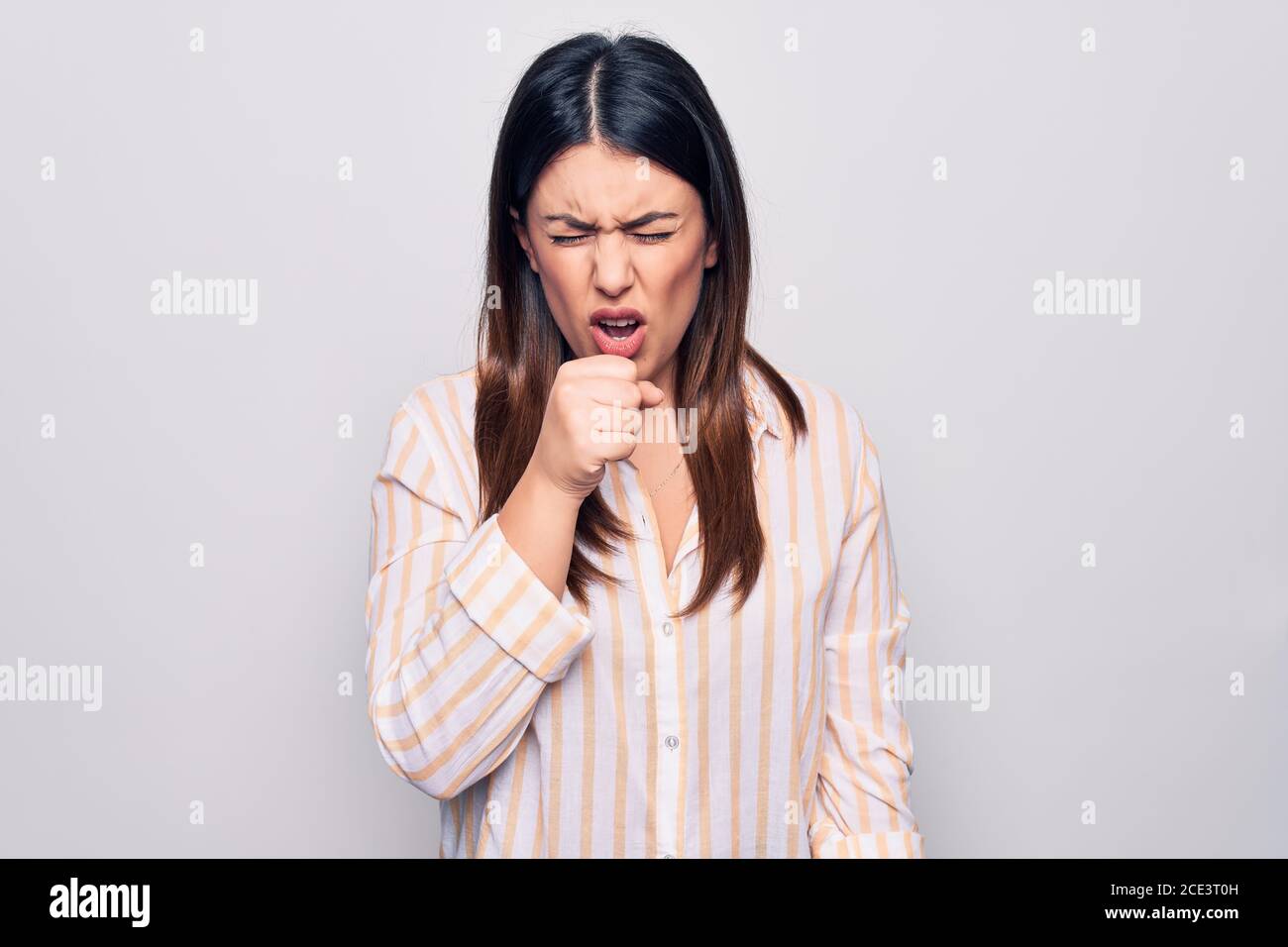 Young beautiful brunette woman wearing casual striped shirt standing ...