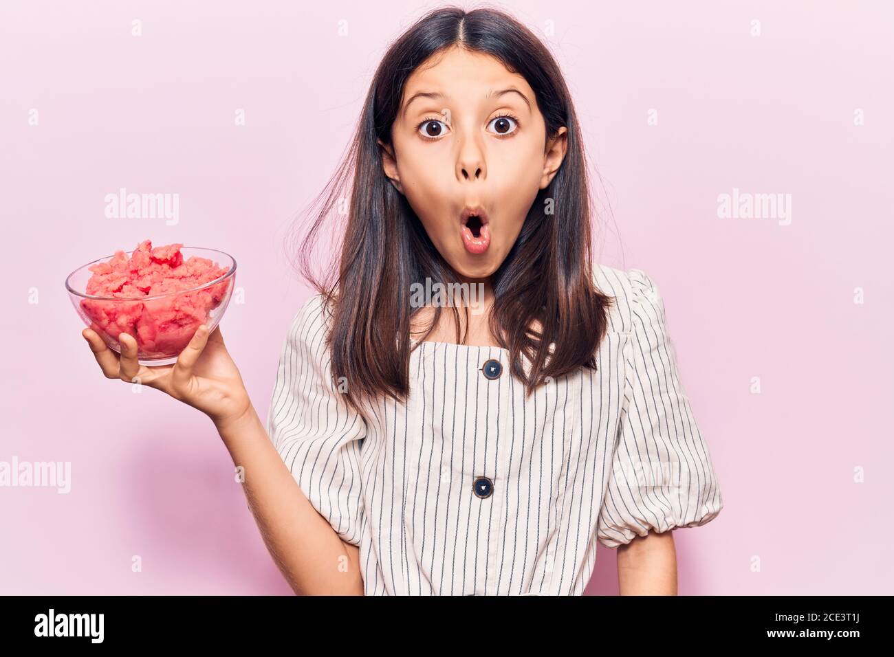 Beautiful child girl holding ice cream scared and amazed with open ...