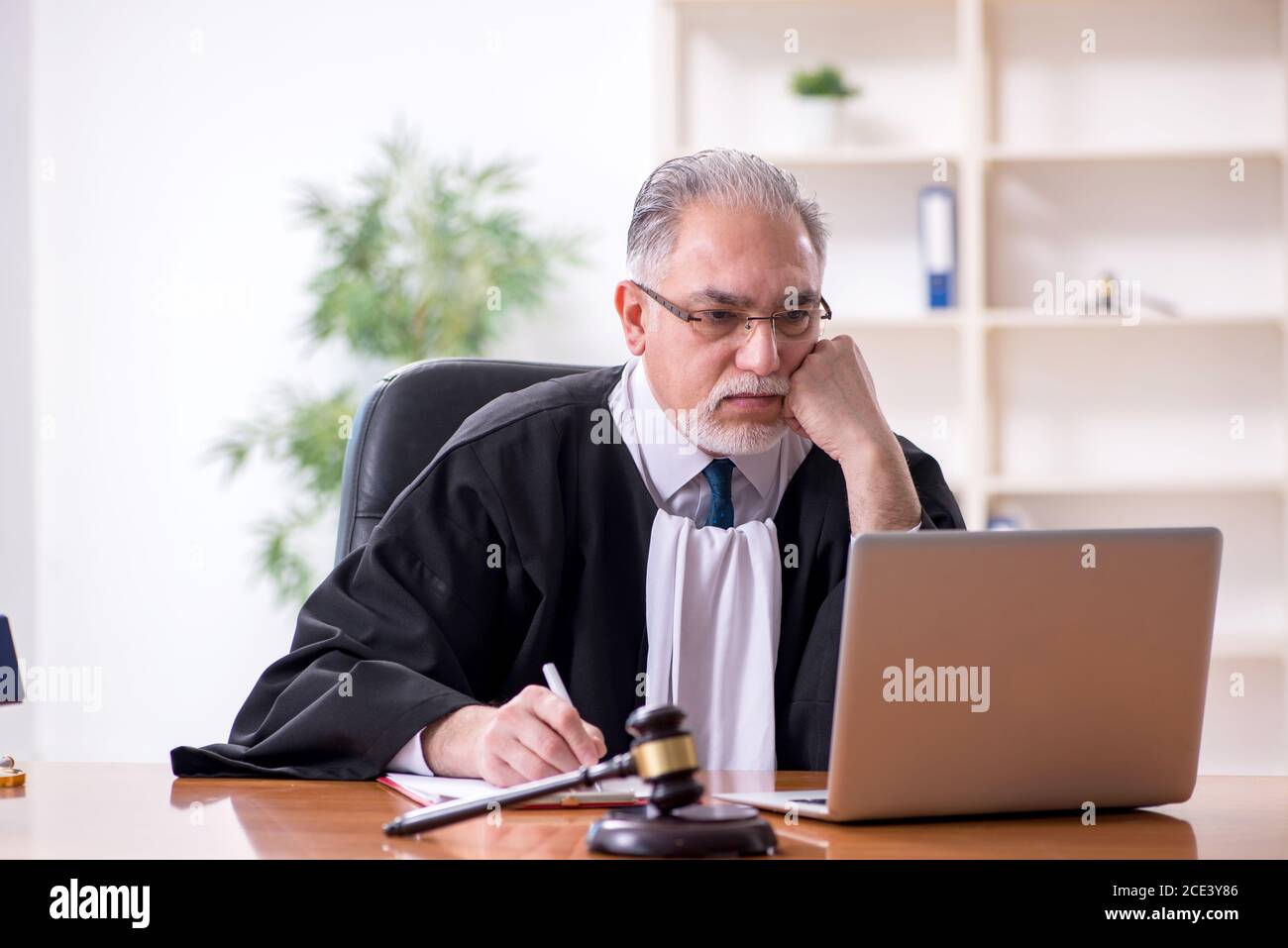 Old male judge working in the courthouse Stock Photo - Alamy