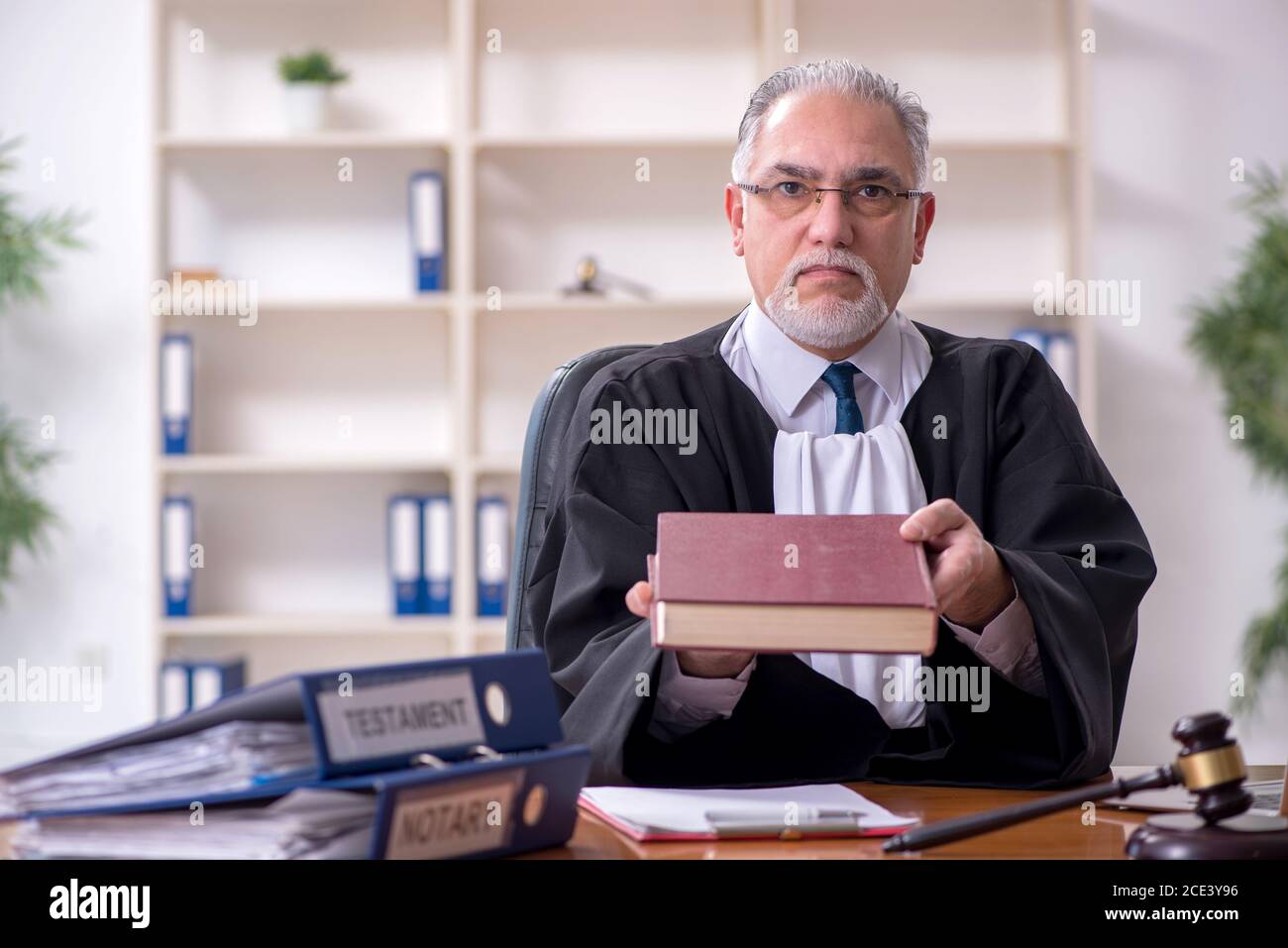 Old male judge working in the courthouse Stock Photo - Alamy