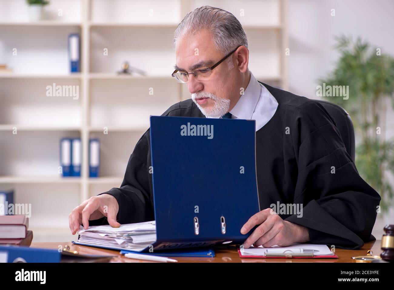 Old male judge working in the courthouse Stock Photo - Alamy