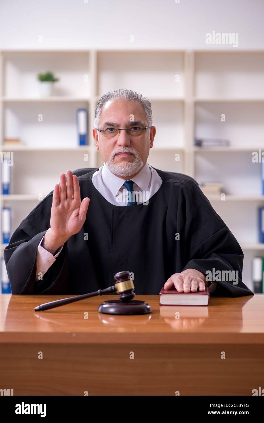 Old male judge working in the courthouse Stock Photo - Alamy