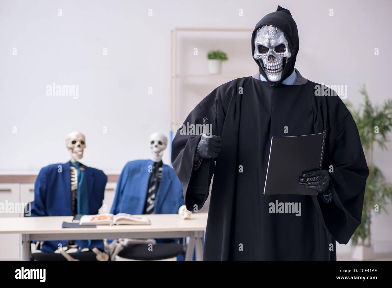Funny business meeting with the devil and skeletons Stock Photo - Alamy