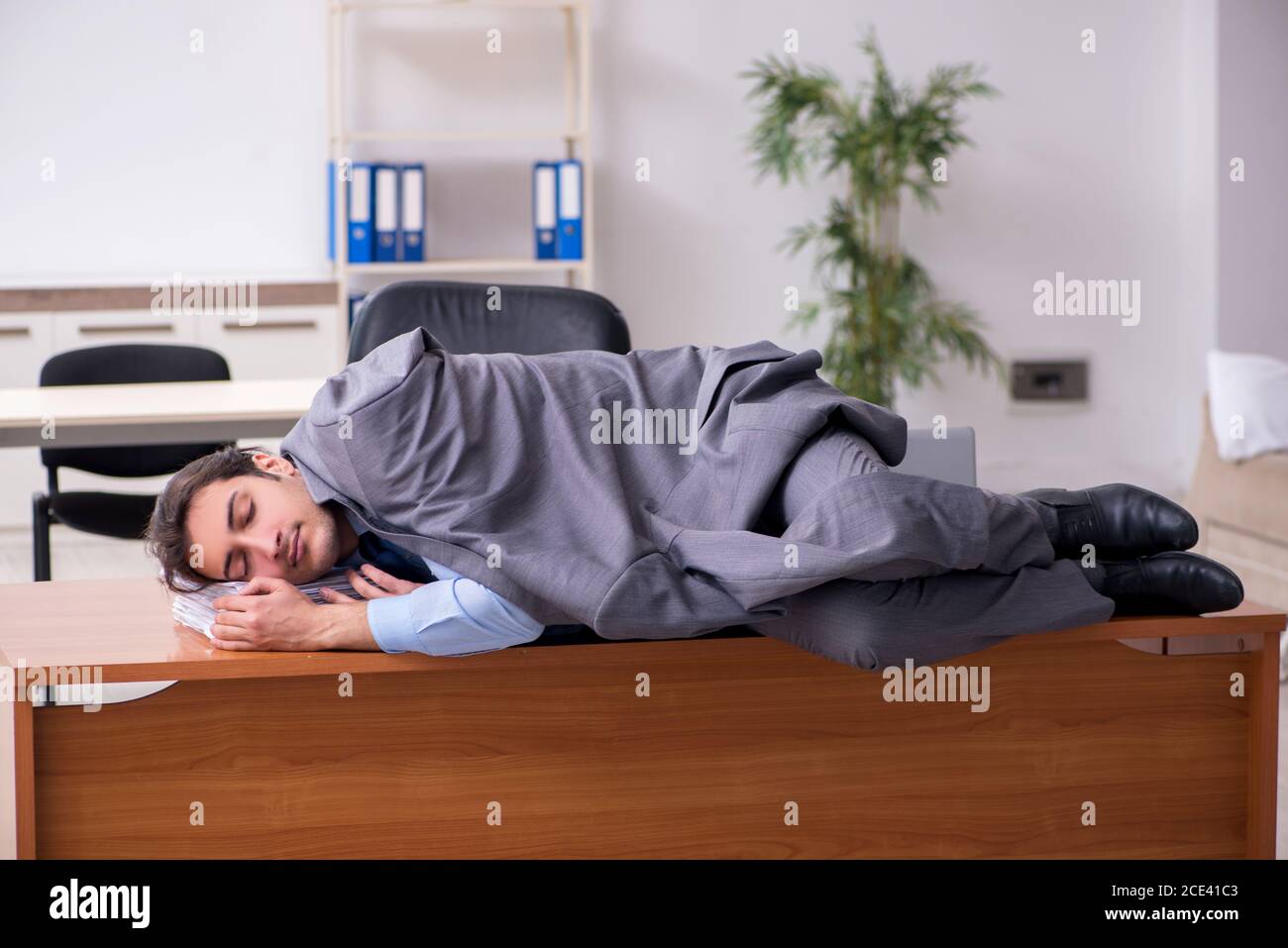 Young employee sleeping in the office Stock Photo - Alamy