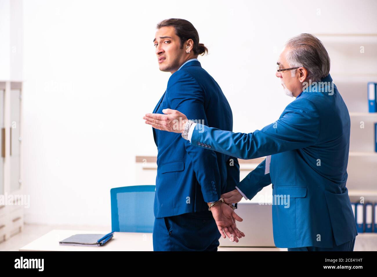 Male employee and cop in police investigation Stock Photo - Alamy