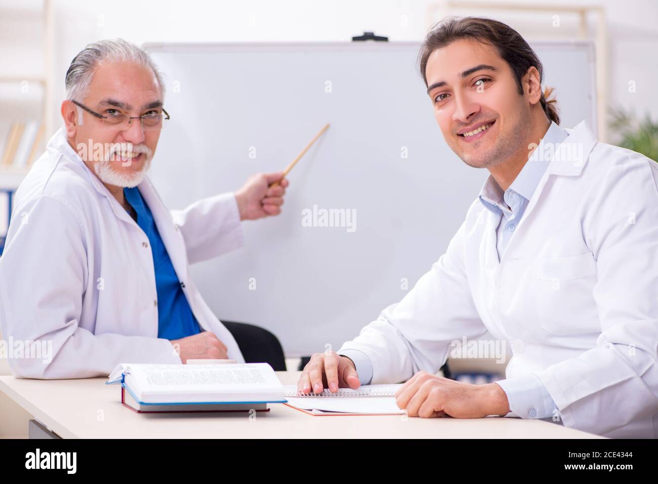Experienced doctor teaching young assistant Stock Photo - Alamy