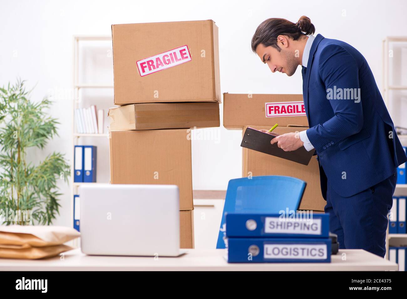 Young logistics specialist working in the office Stock Photo - Alamy
